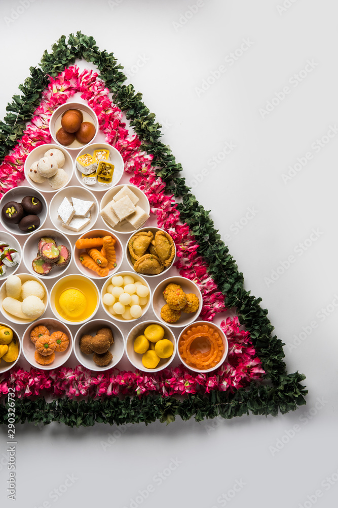 Flower Rangoli with sweets/mithai and diya in bowls for Diwali or any ...