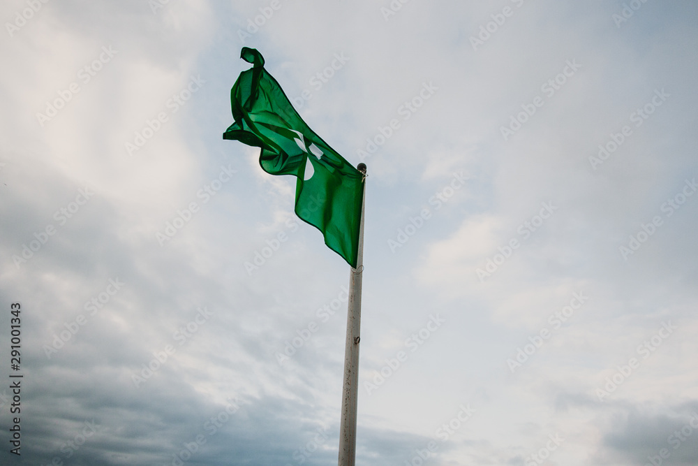 Rescue green flag at the beach weaving Stock Photo | Adobe Stock