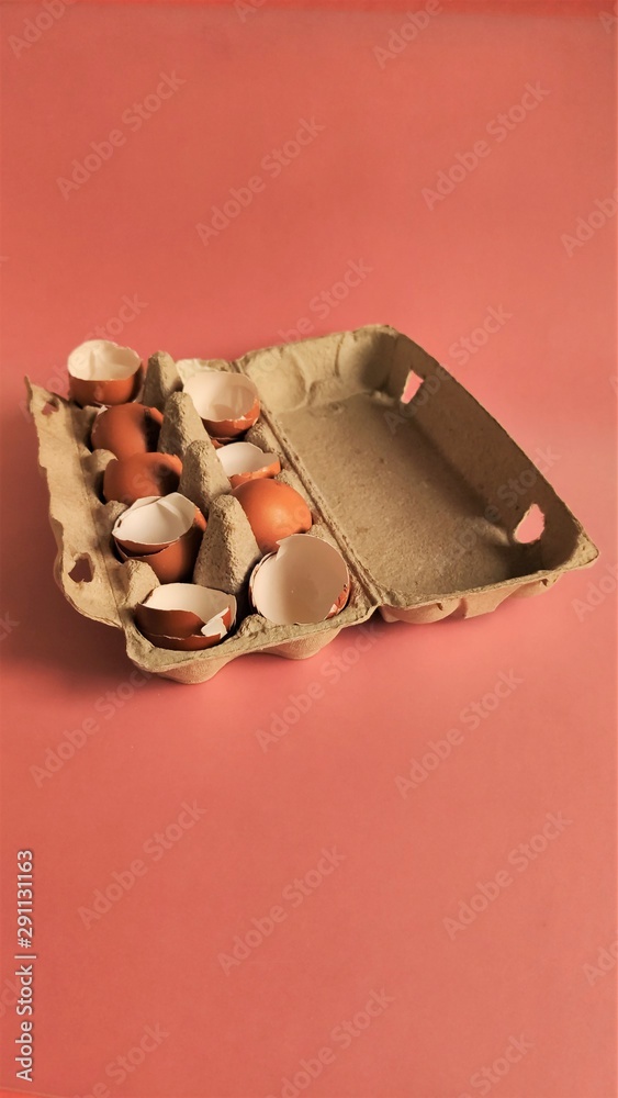 Eggshell halves in recycled cardboard packaging on a pink background ...