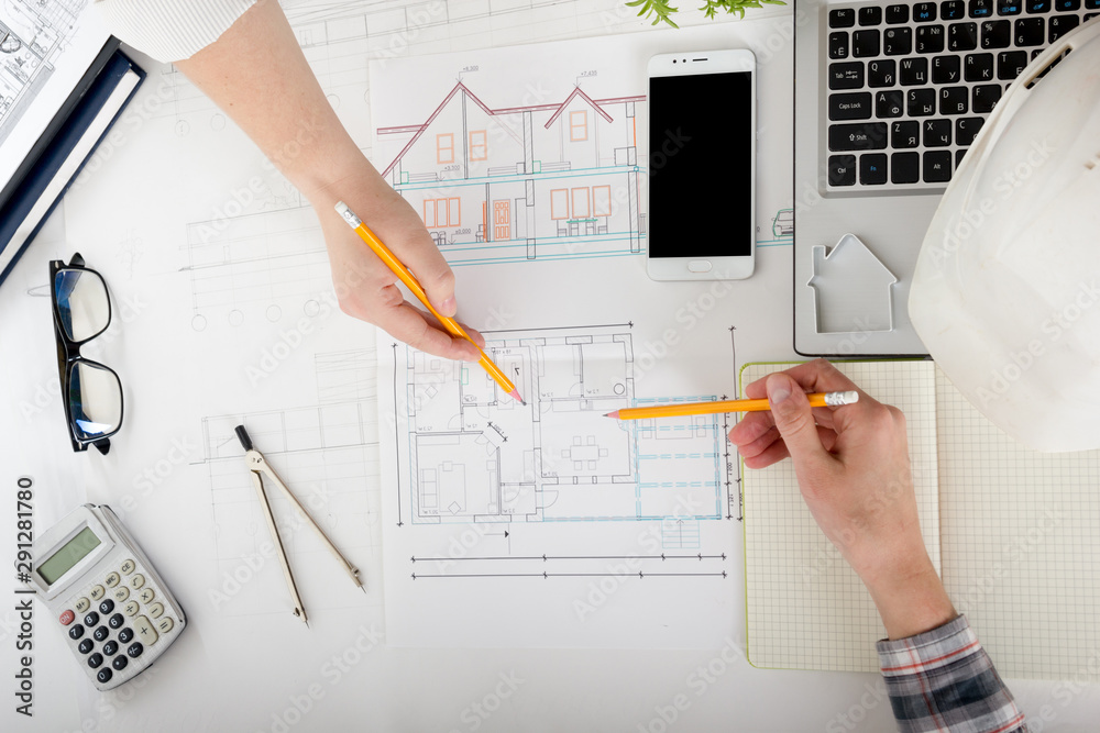 Architects working on blueprint, real estate project. Architect ...