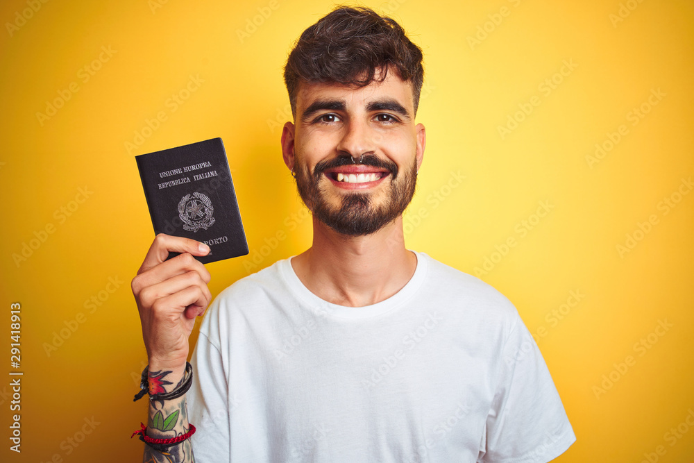 Young man with tattoo wearing Italy Italian passport over isolated ...