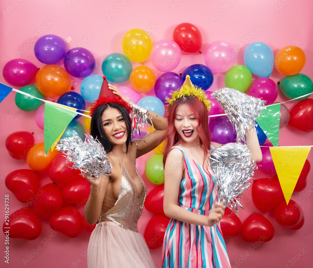 Two beautiful girl friends celebrate party together dancing on ...