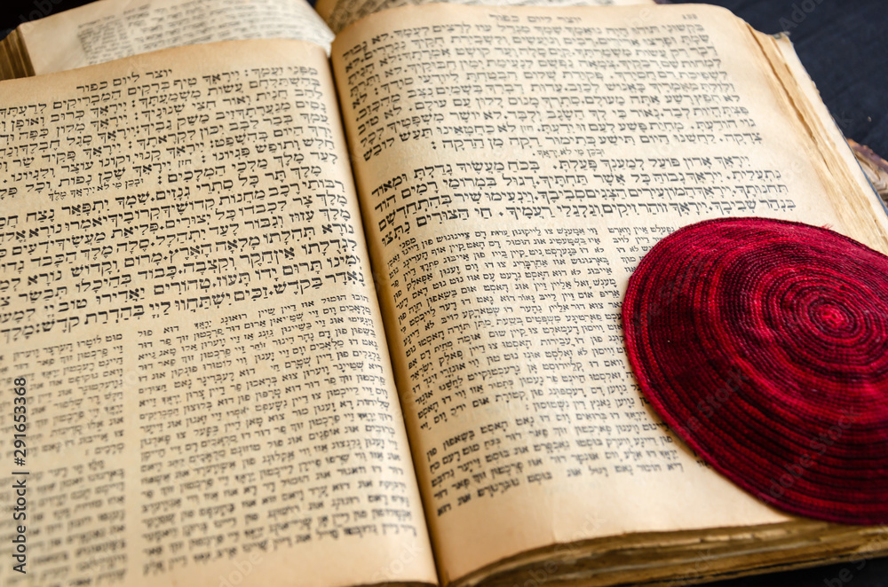 Stock-Foto „Opened old Jewish Bible. Red knitted jewish bale lies on an ...