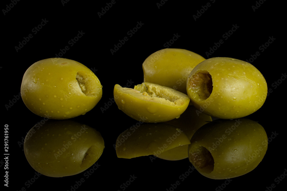 Group of three whole one half of pitted green olive isolated on black ...