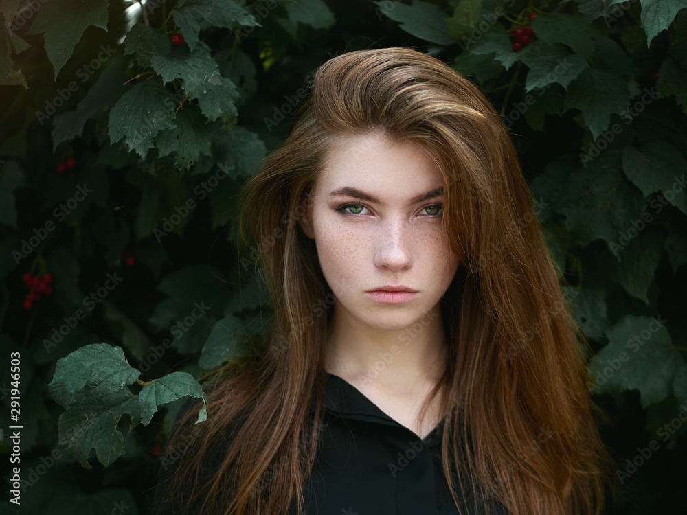 Closeup headshot of a beautiful serious caucasian red haired woman with ...