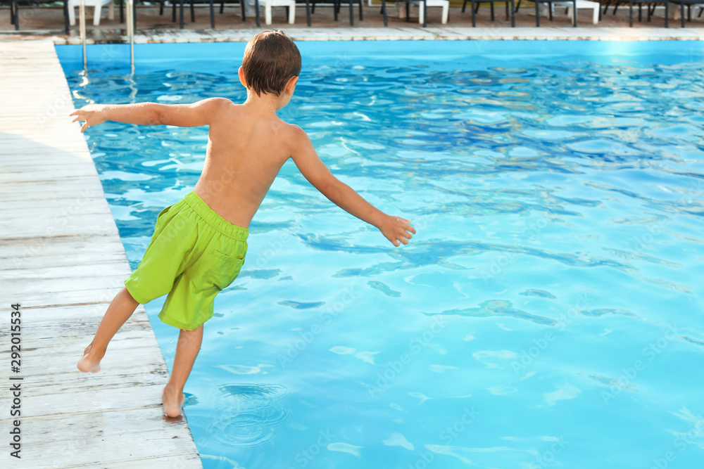 Little child jumping in outdoor swimming pool. Dangerous situation ...