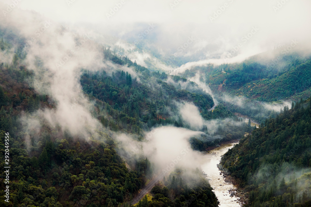 Mist, fog and storm clouds moving over railroad tracks and mountains in ...