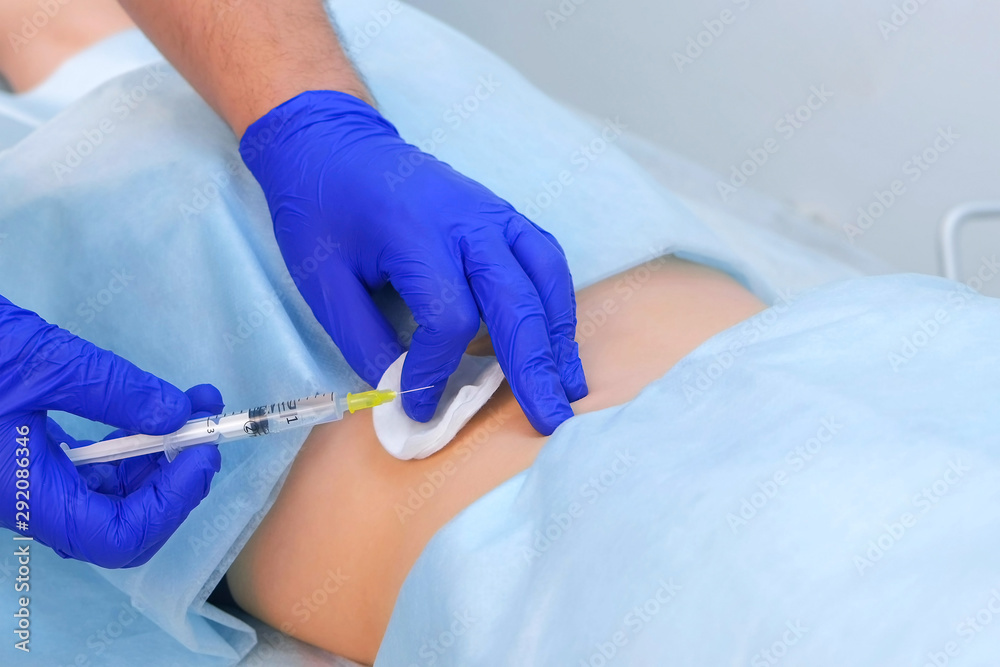 Surgeon in gloves gives injection of local anesthesia to patient before ...