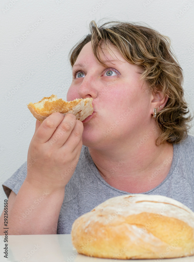 Fat girl eating bread. Hunger. Eating. Overweight woman eating a bun ...