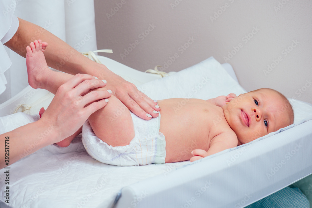 caucasian mother applying baby powder before putting diapers on her ...