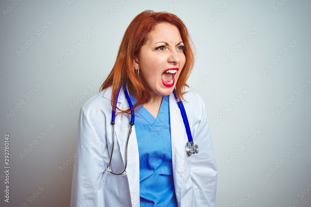 Young redhead doctor woman using stethoscope over white isolated ...