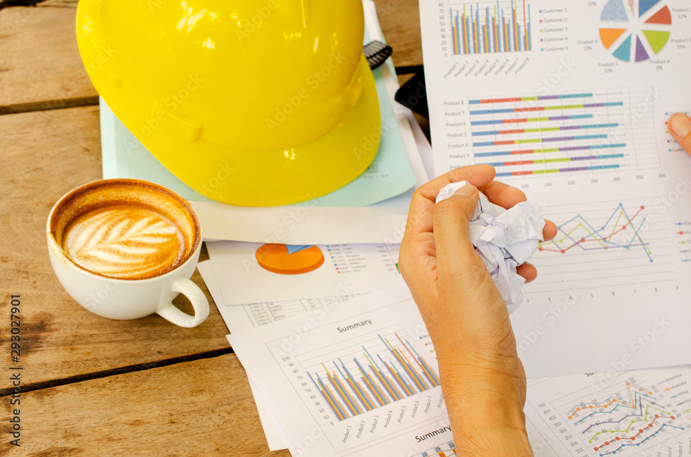 Hand keeping crumpled paper with document chart and coffee cups on work ...