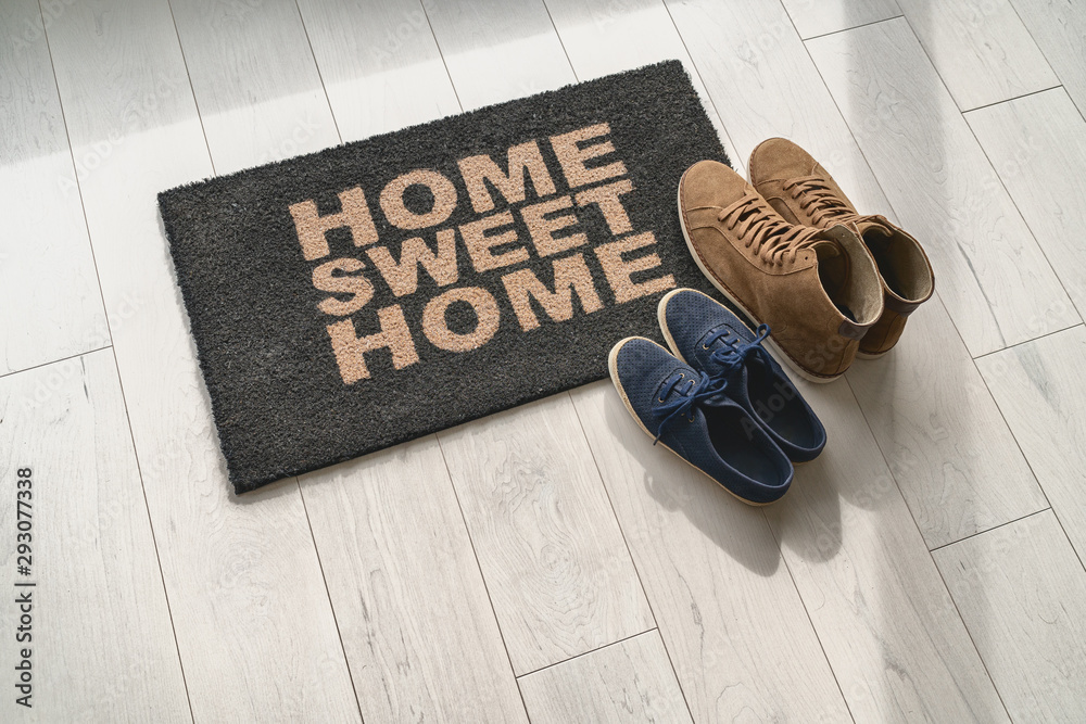 Стоковое фото «Home sweet home doormat at condo door entrance with ...