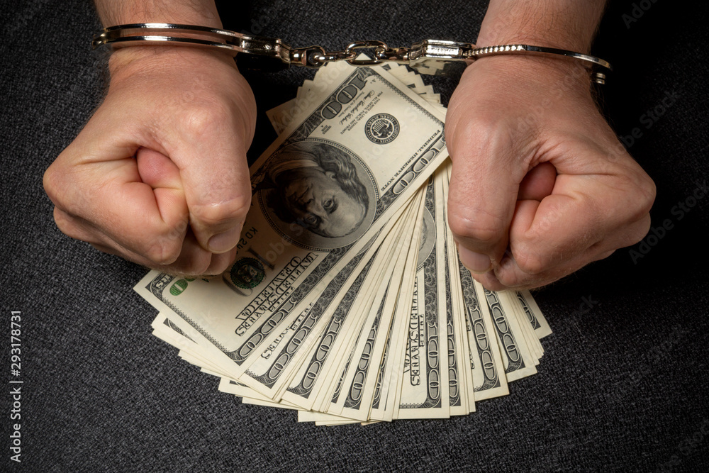 Man s hands in handcuffs and many hundred dollar american banknotes on ...