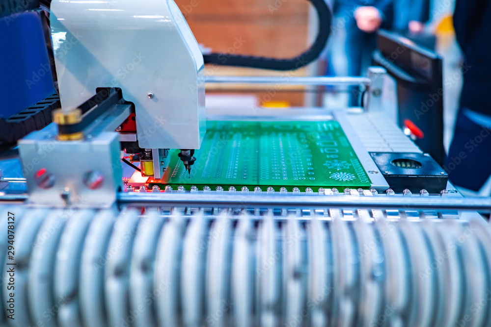 Automated production of printed circuit boards. The robot assembles the ...