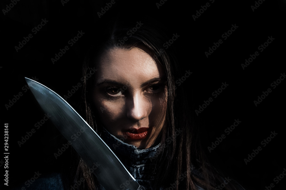 Beautiful smiling brunette girl attacs with a big scary shiny knife ...