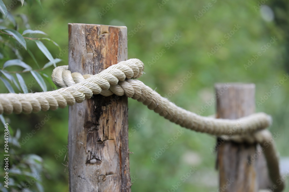 Foto de Stock Seil als Absperrung über zwei alte Holzpfosten gespannt ...