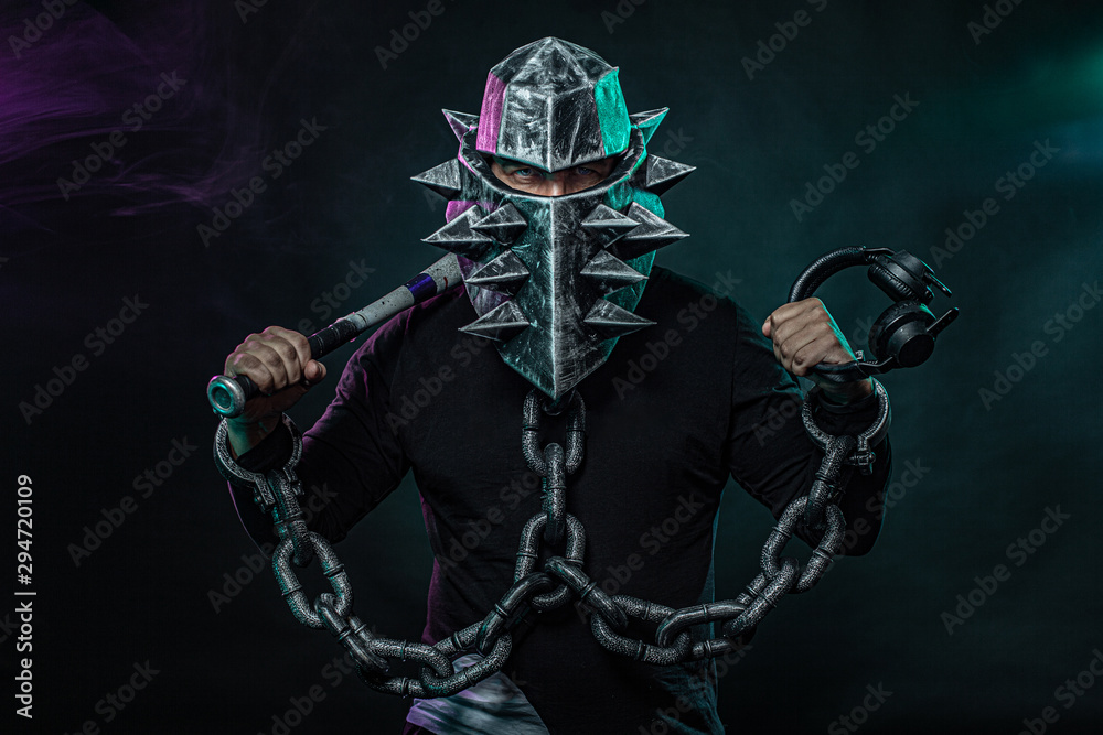 Mysterious man in a helmet with a bat and chains in black wear. Fantasy ...