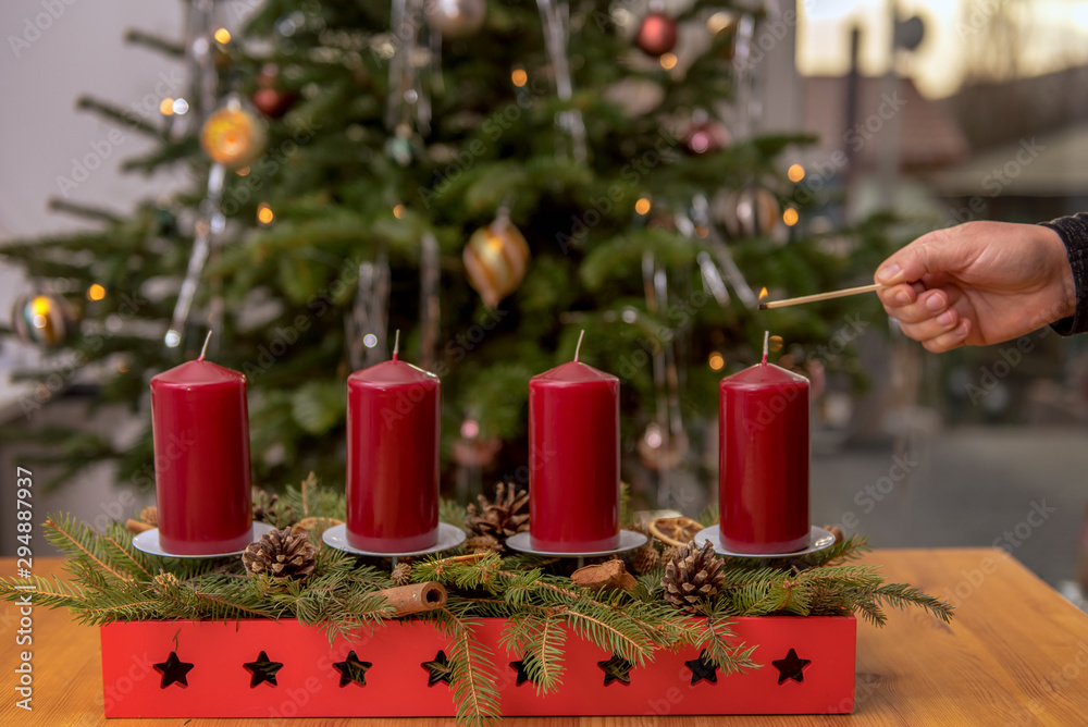 Foto de Stock omeone lighomeone lights the first Advent candle from the ...