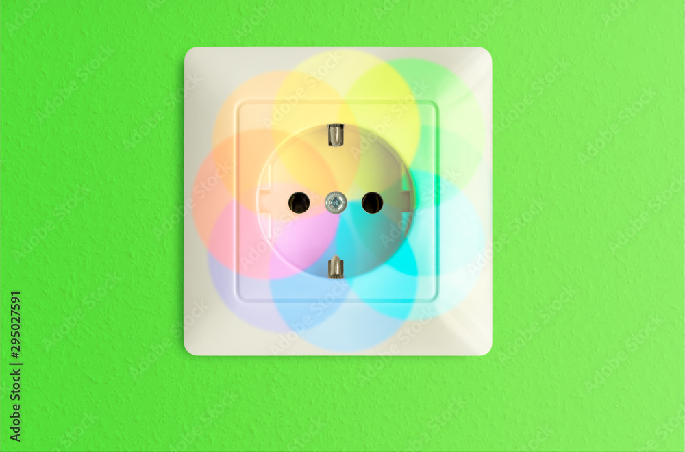 power outlet with spectral prism colours of rainbow on green wall ...