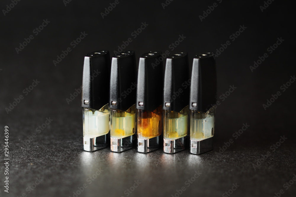 e-juice vape refill pods with liquids of different shades of orange ...