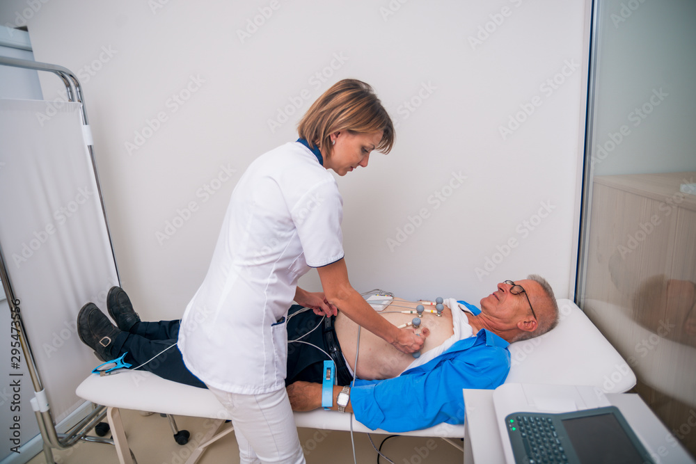 Female(doctor) nurse performs EKG test on an older man. Stock Photo ...