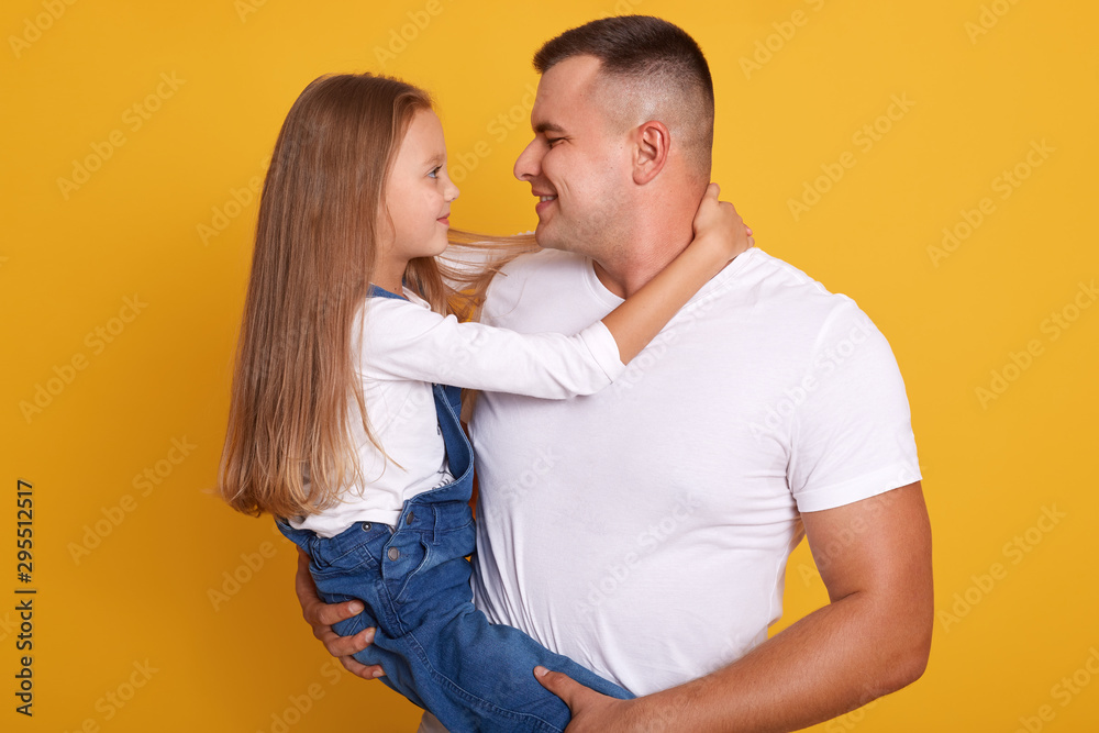 Horizontal shot of young handsome man and his adorable daughter joking ...