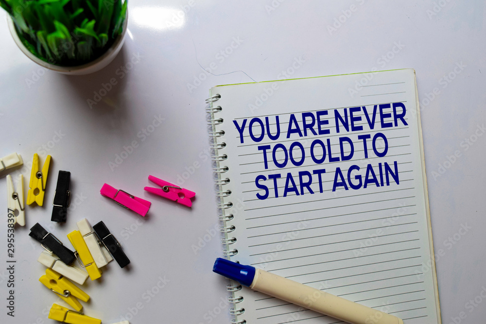 You Are Never Too Old To Start Again text on a book at office desk ...