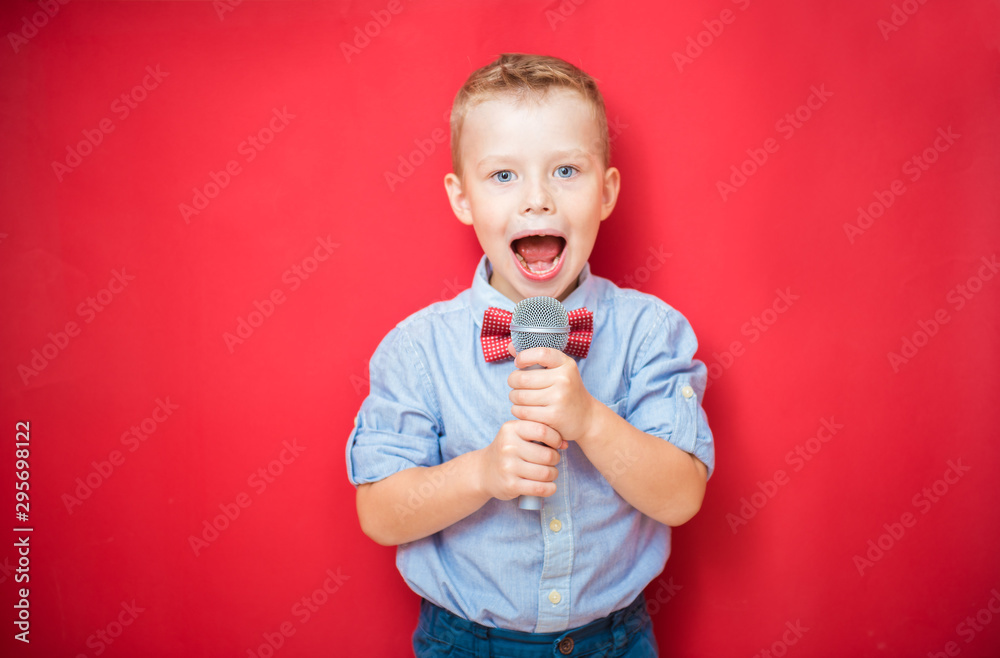 Little boy singing with microphone on red background. Music, song and ...