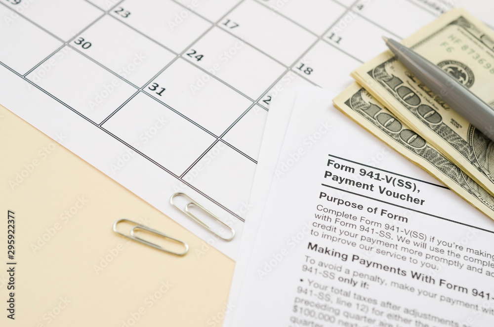 IRS Form 941-V Payment Voucher blank lies with pen and many hundred ...