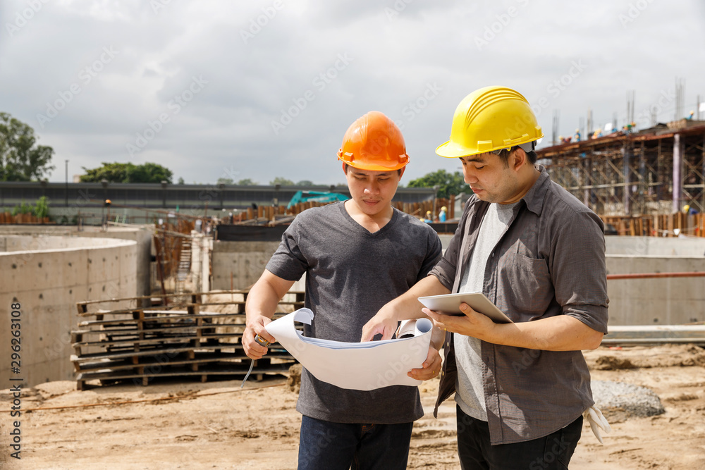 Team of construction workers discussing project details with blueprint ...