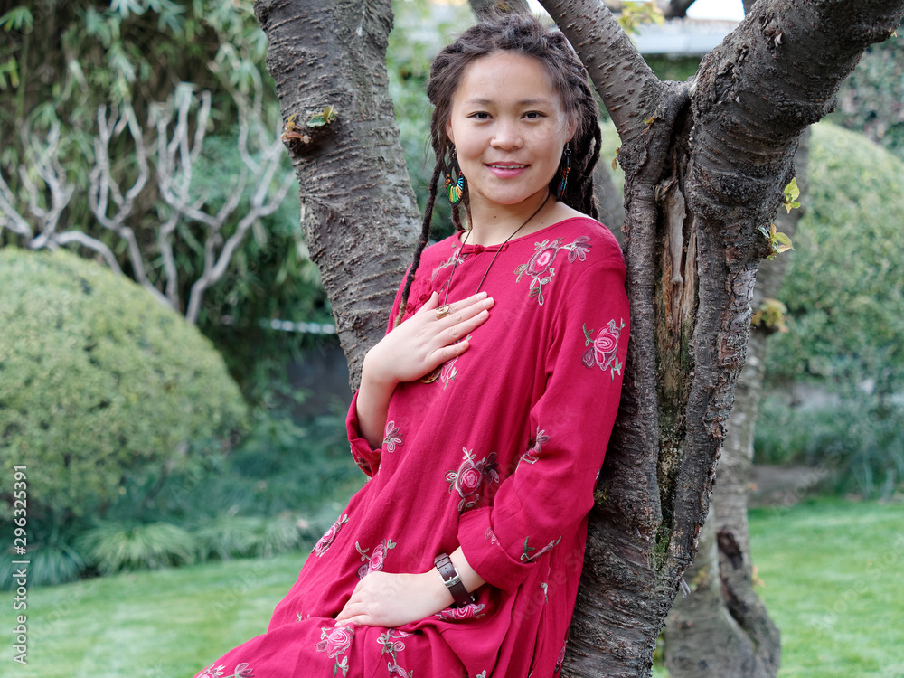 Portrait of a beautiful Chinese girl in red robe with cute dreadlocks ...