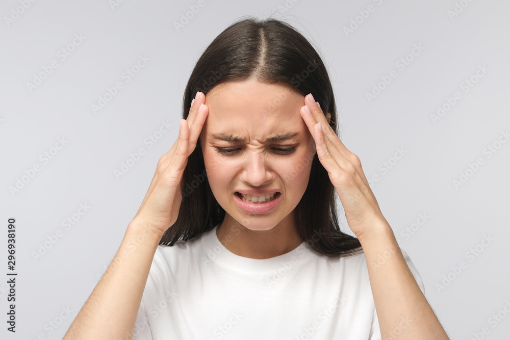 Upset unhappy young woman squeezing head with hands, suffering from ...