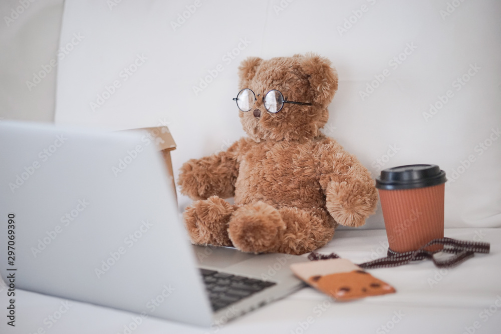 Teddy bear working concept. A cute teddy bear working in bed with a ...