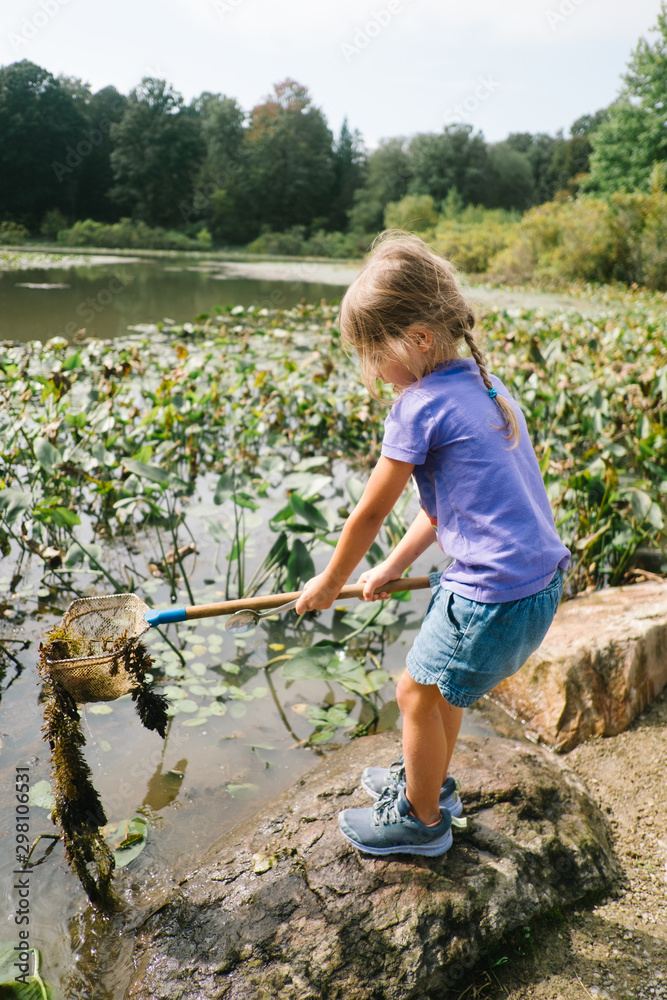 little girl studying pond in nature Stock Photo | Adobe Stock