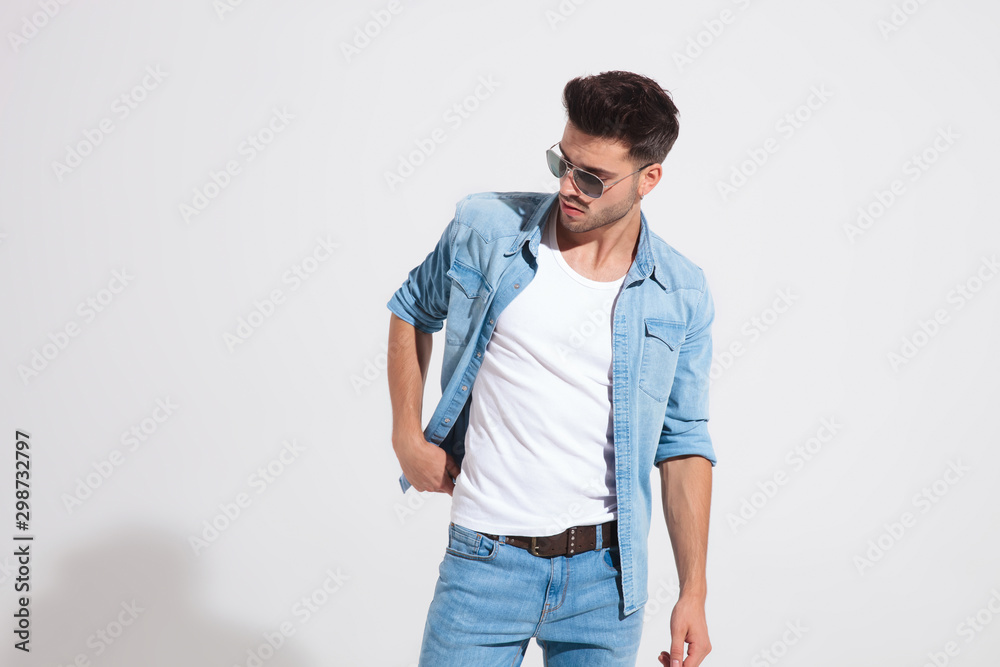Young fashion man holding adjusting his jacket Stock Photo | Adobe Stock