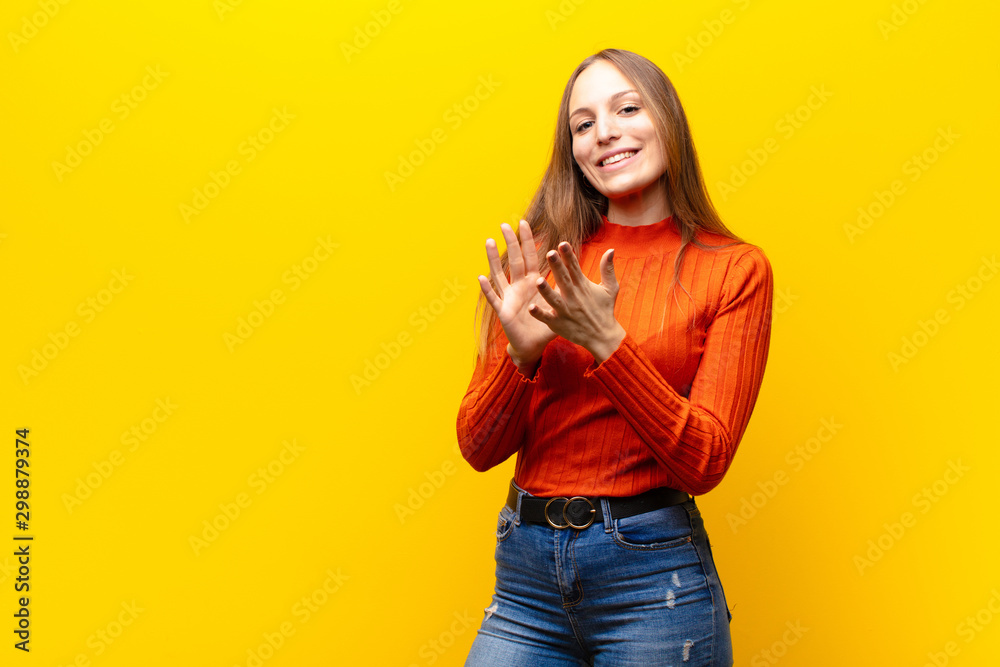 young pretty woman feeling happy and successful, smiling and clapping ...