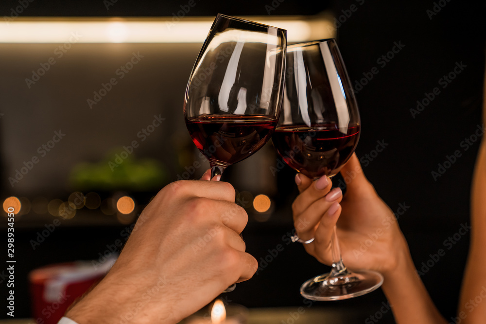 Foto Close up shot of man and woman toasting and drinking red wine from ...