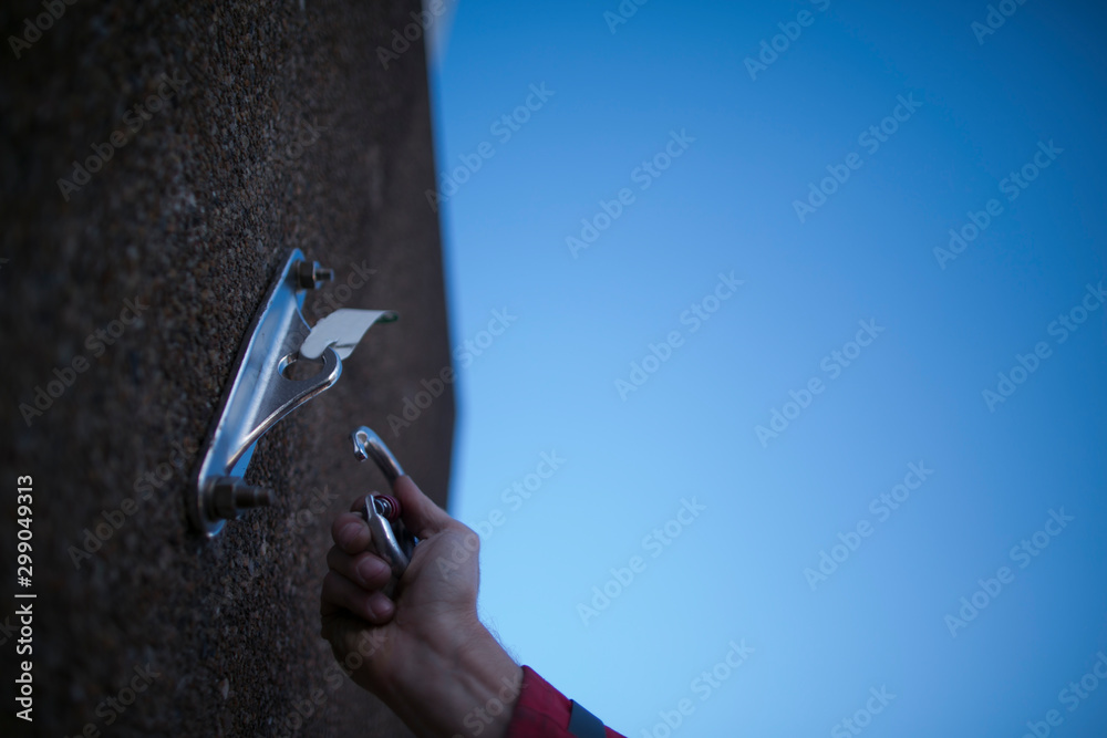 Worker clipping locking carabiner into industrial rope access fall ...