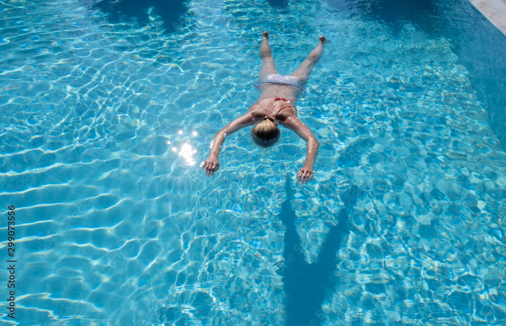 Woman face down in a swimming pool Stock Photo | Adobe Stock