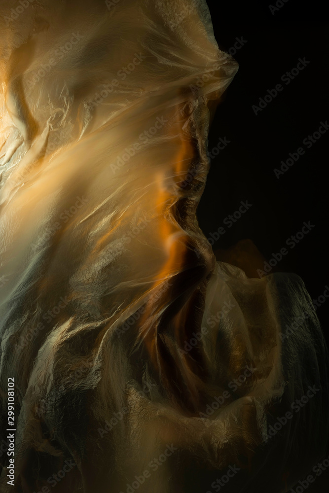 Body of a beautiful girl gracefully fits a cellophane film fluttering ...