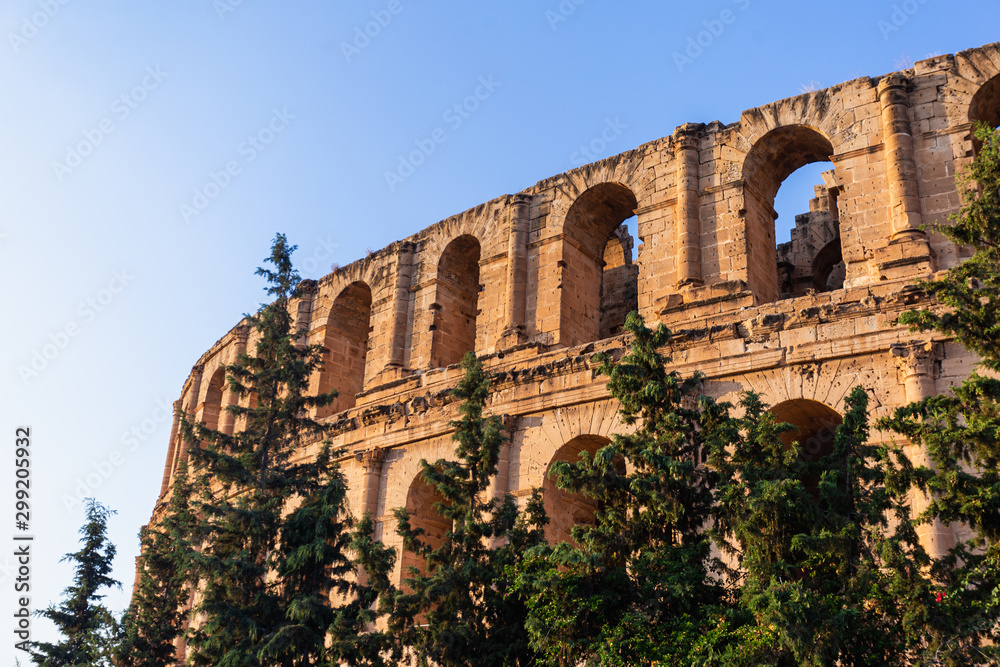 Amphitheater in El Djem from outside. Completed part with arches of ...