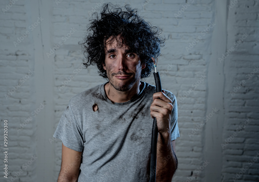 Funny image of man holding electrical cable after getting electric ...