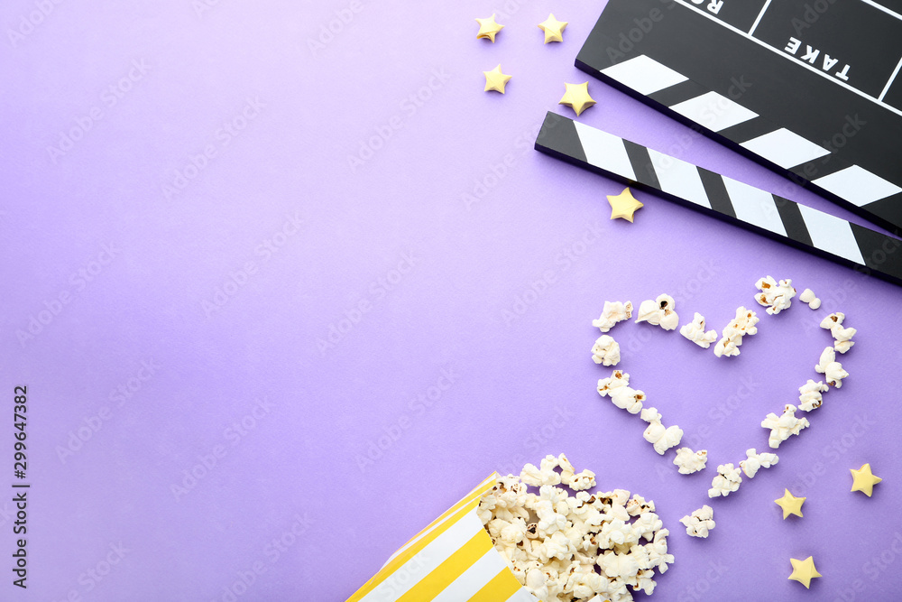 Clapper board with popcorn on purple background Stock Photo | Adobe Stock