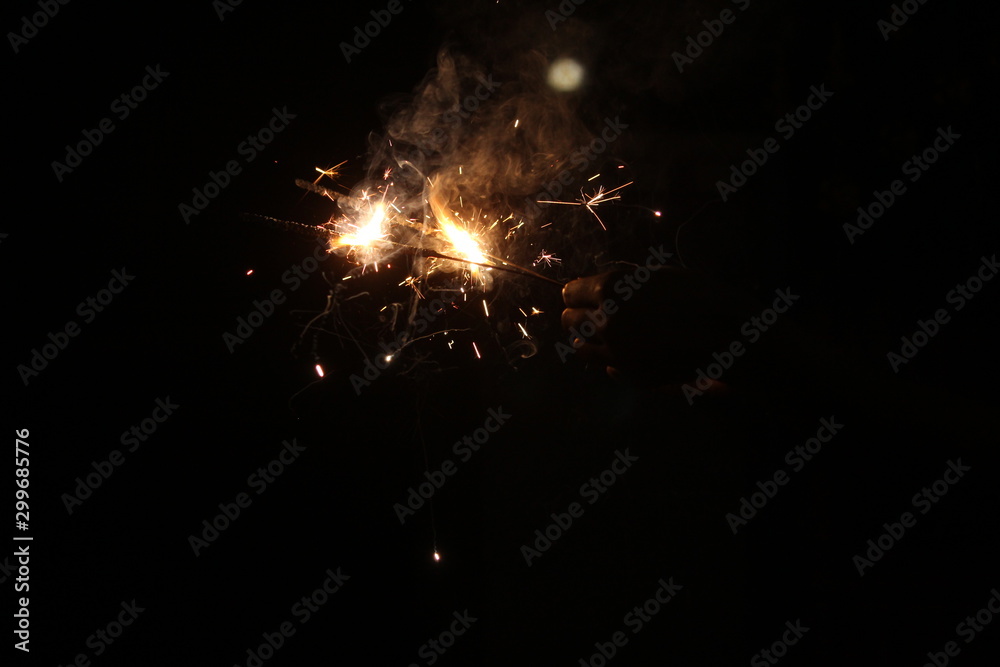 human Hand holding the sparkler on sparkling with dark background with ...