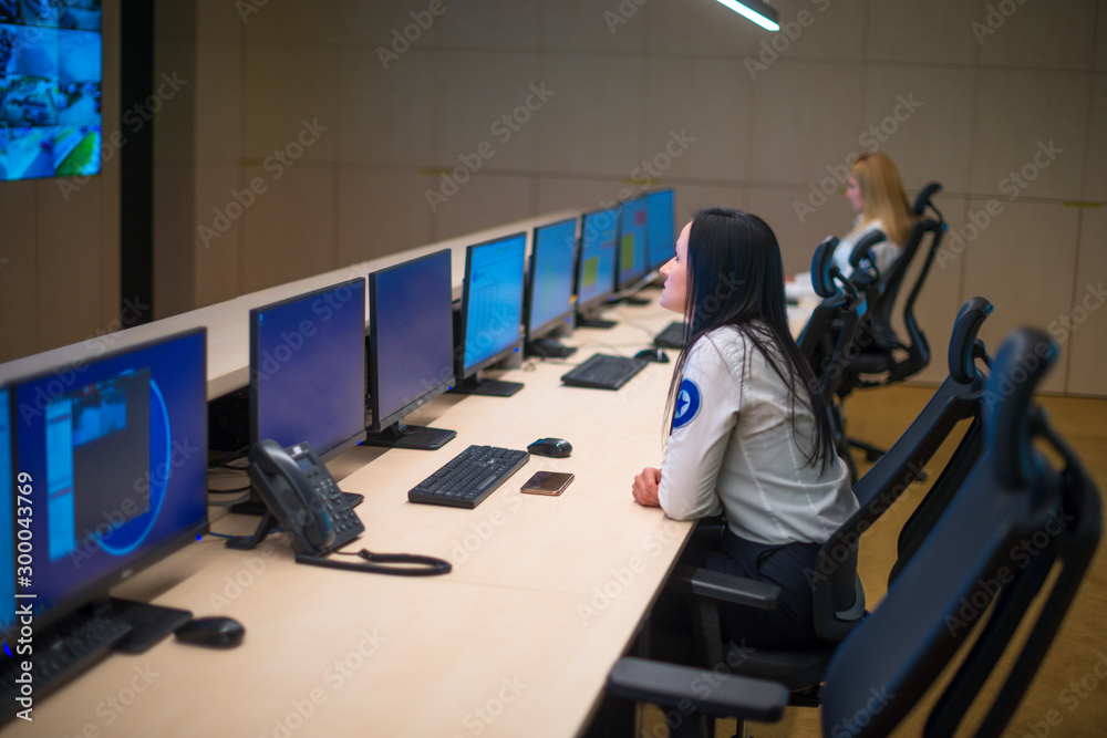 Security guard monitoring modern CCTV cameras in a surveillance room ...
