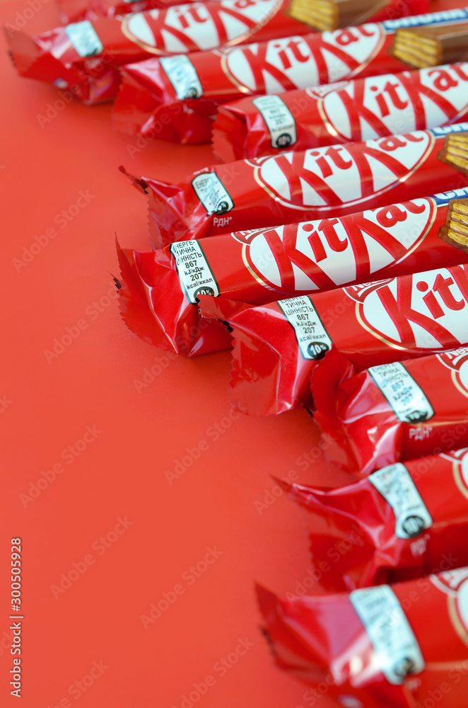 Kit Kat chocolate bars in red wrapping lies on yellow background is now ...