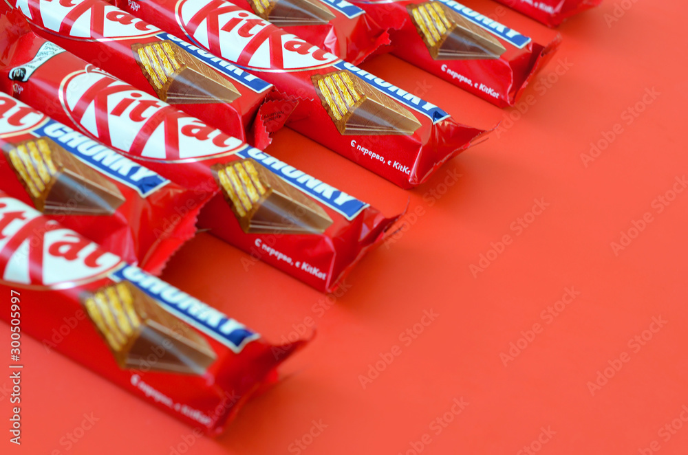 Kit Kat chocolate bars in red wrapping lies on yellow background is now ...