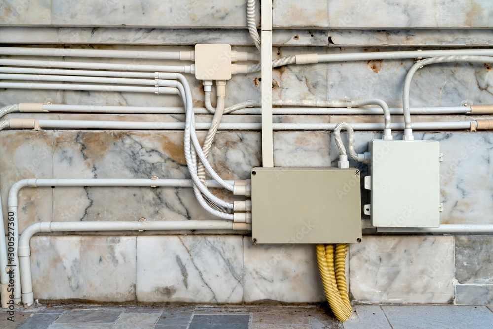 electrical junction boxes with plastic pipe connection on marble wall ...