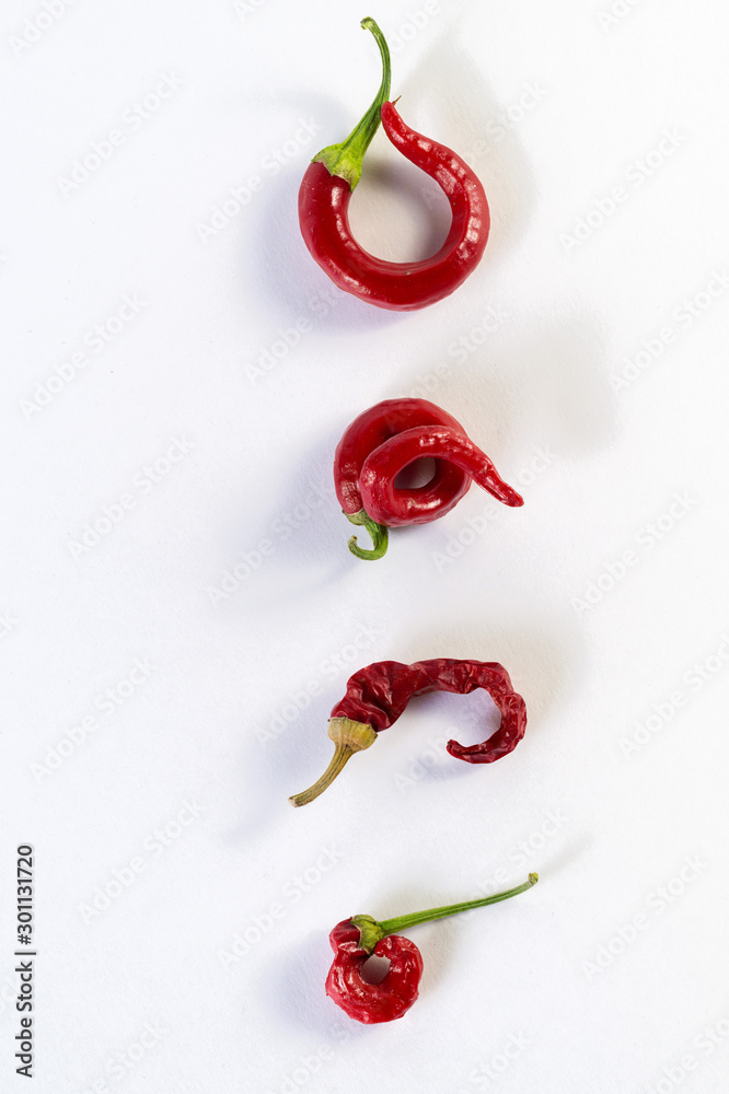 Chili peppers, red, non-standard, unusual shape, laid out in a line ...